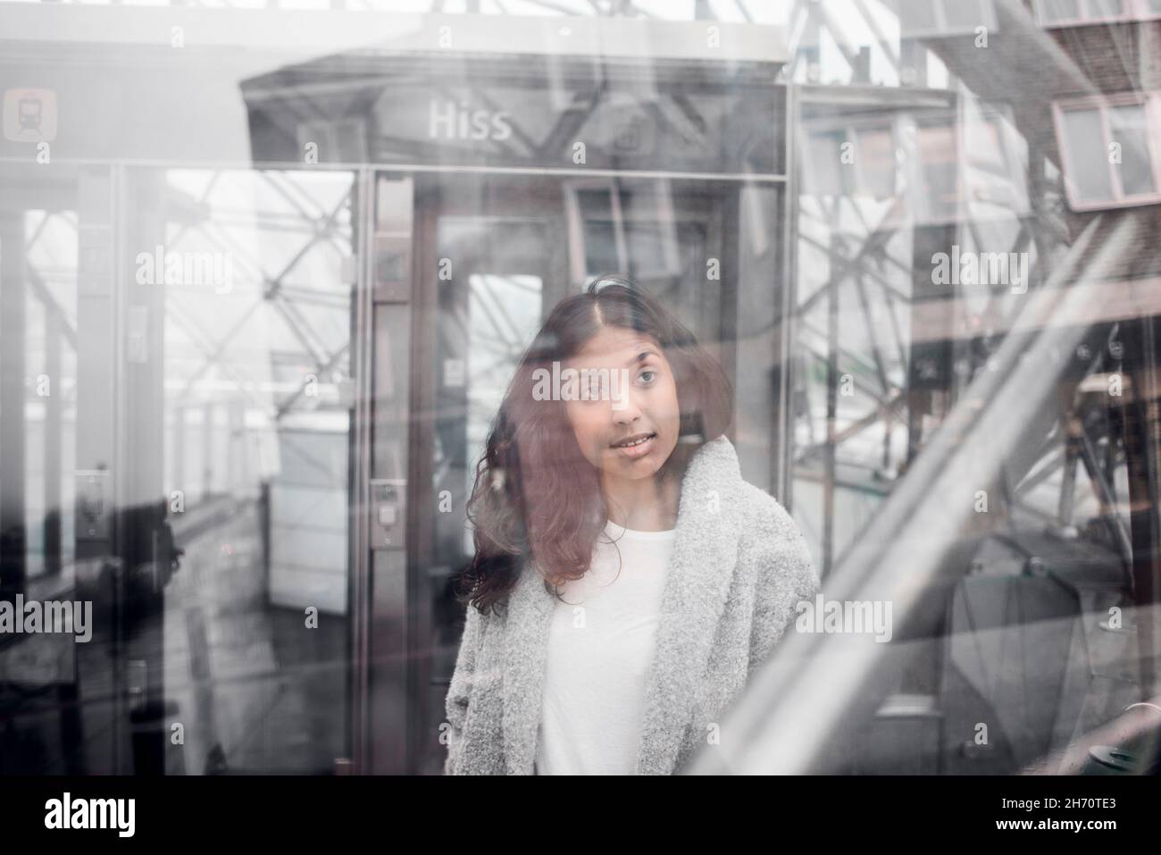 Young woman standing behind glass Stock Photo - Alamy