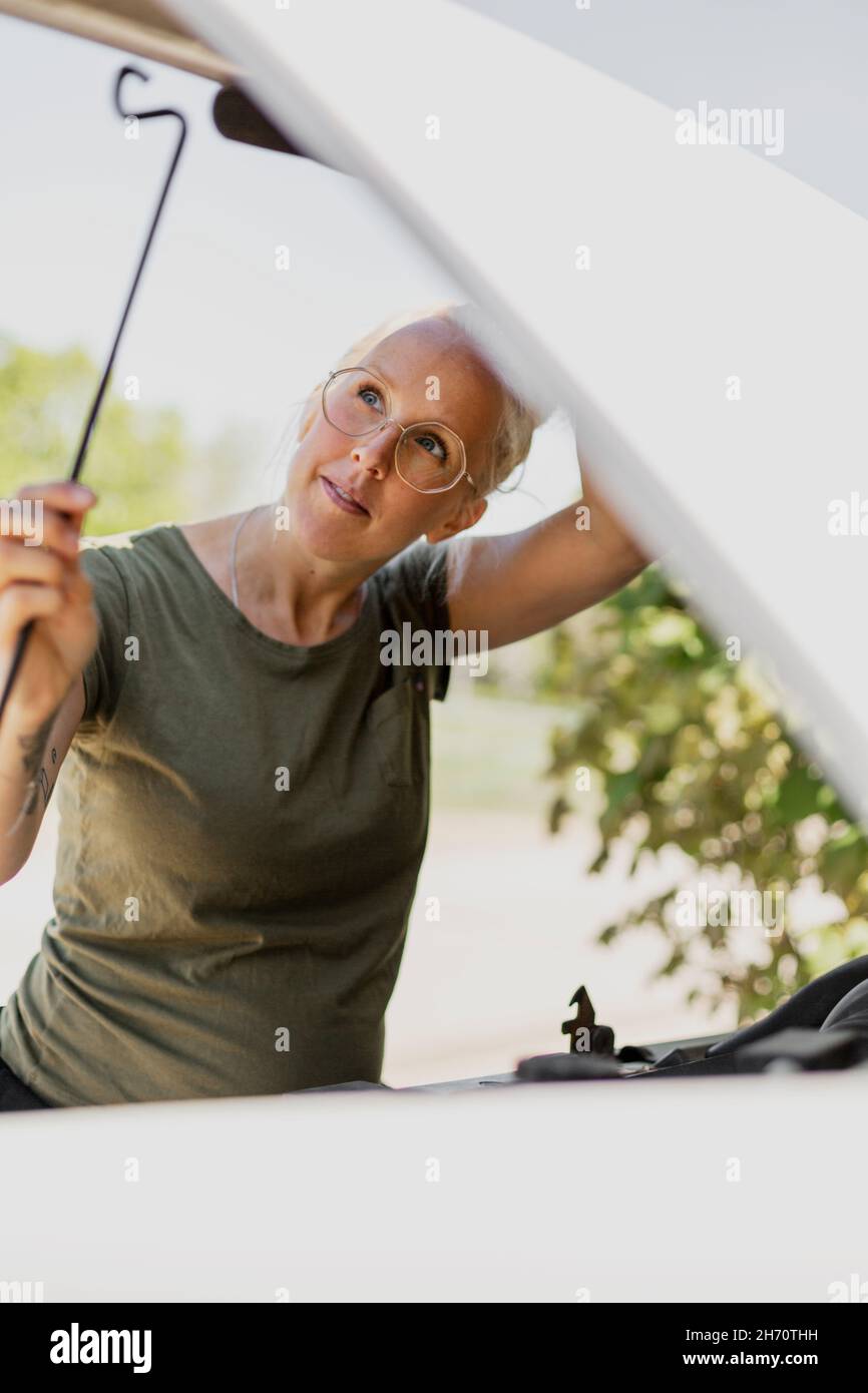 Woman opening bonnet Stock Photo - Alamy