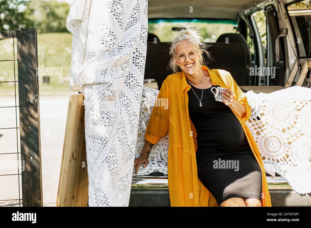 Woman sitting in open van Stock Photo - Alamy
