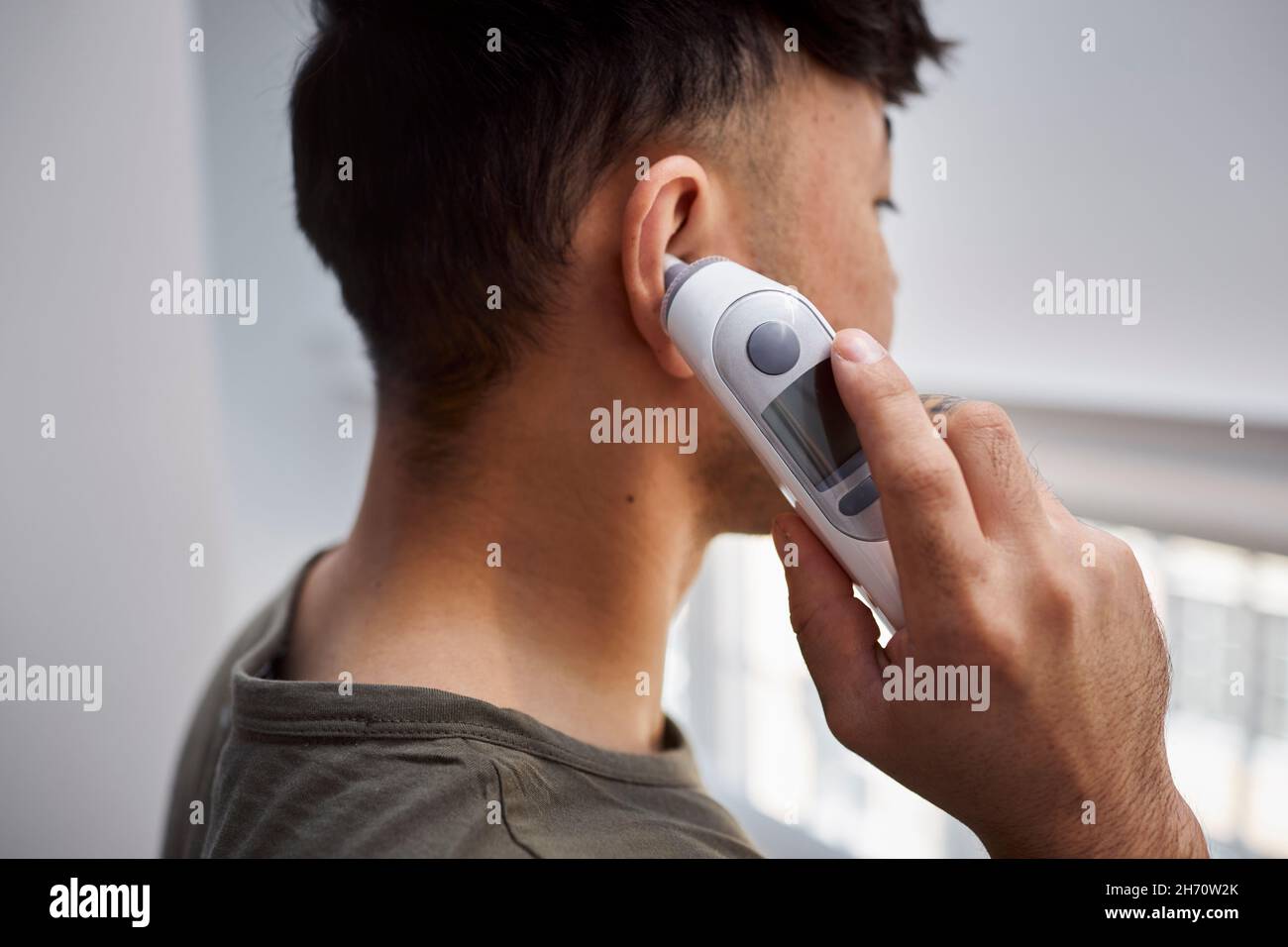 Man checking temperature with digital thermometer Stock Photo - Alamy