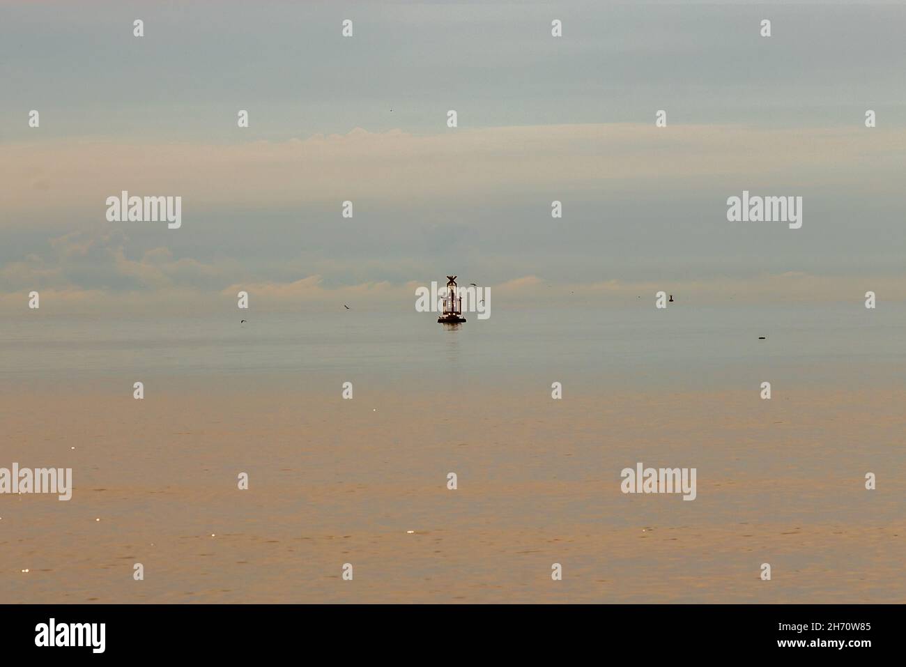 Lonely marine red signal buoy in a beautiful blue sea to warn the ships ...