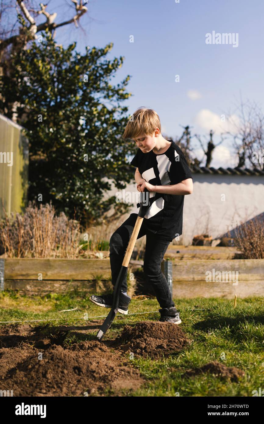 Boy working in garden Stock Photo - Alamy
