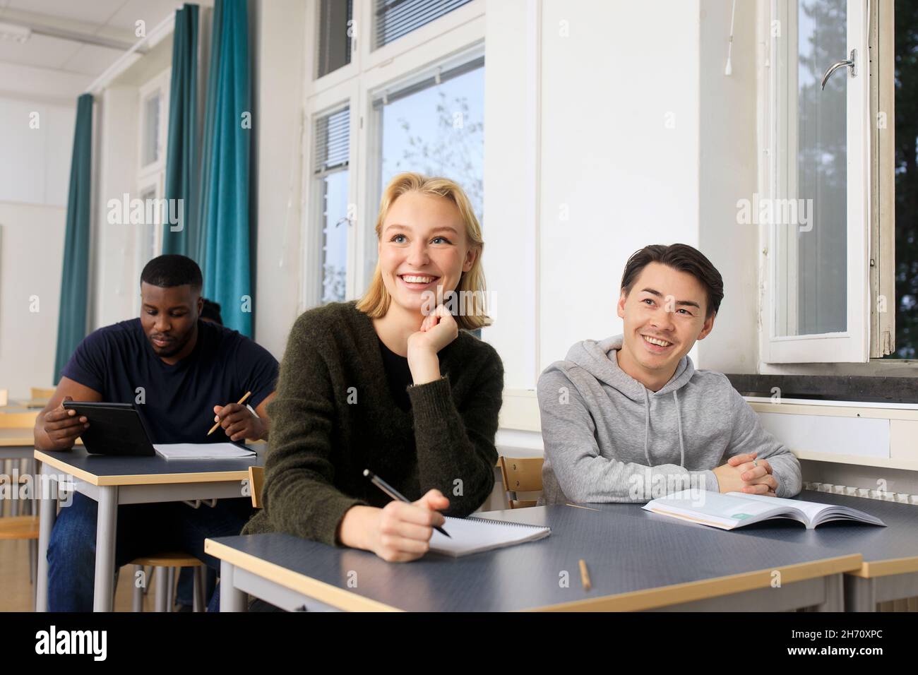 Smiling students in classroom Stock Photo - Alamy