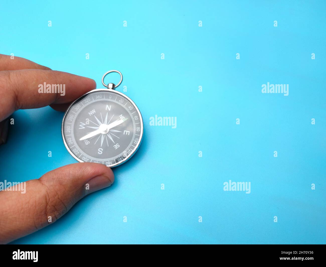 Hand holding compass on a blue background with copy space.y Stock Photo ...