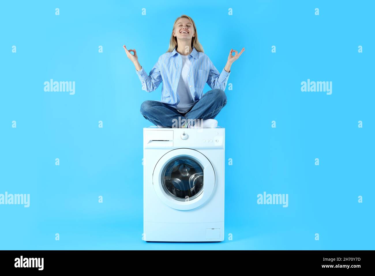Concept of housework with washing machine and girl on blue background ...