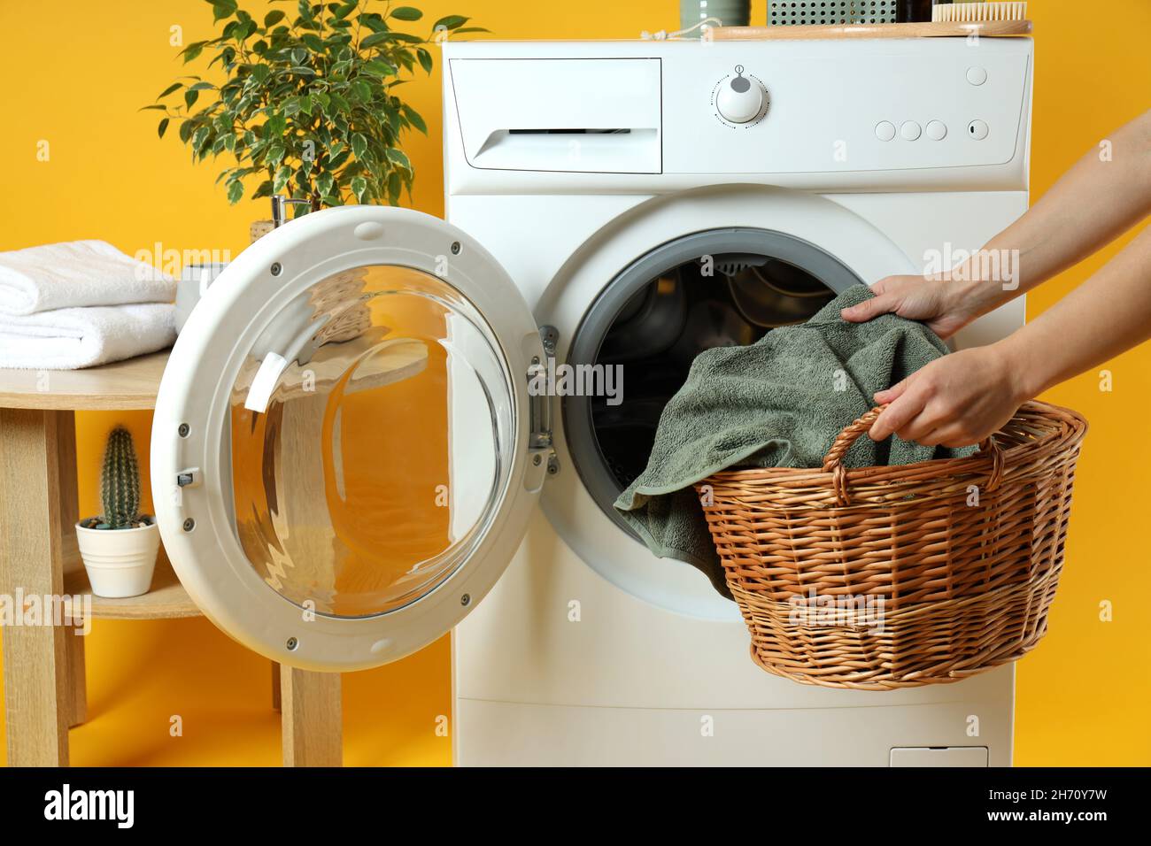 Concept of housework with washing machine on yellow background Stock ...