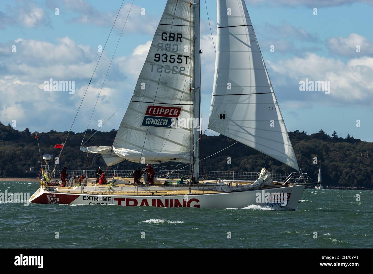 Training sailing boat with full sails in Solent Stock Photo - Alamy