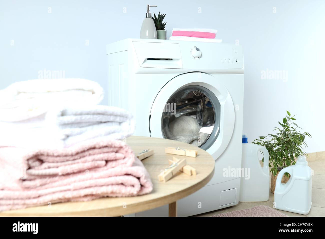 Concept of housework with washing machine against white wall Stock ...