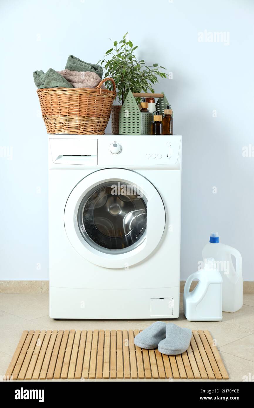 Concept of housework with washing machine against white wall Stock ...