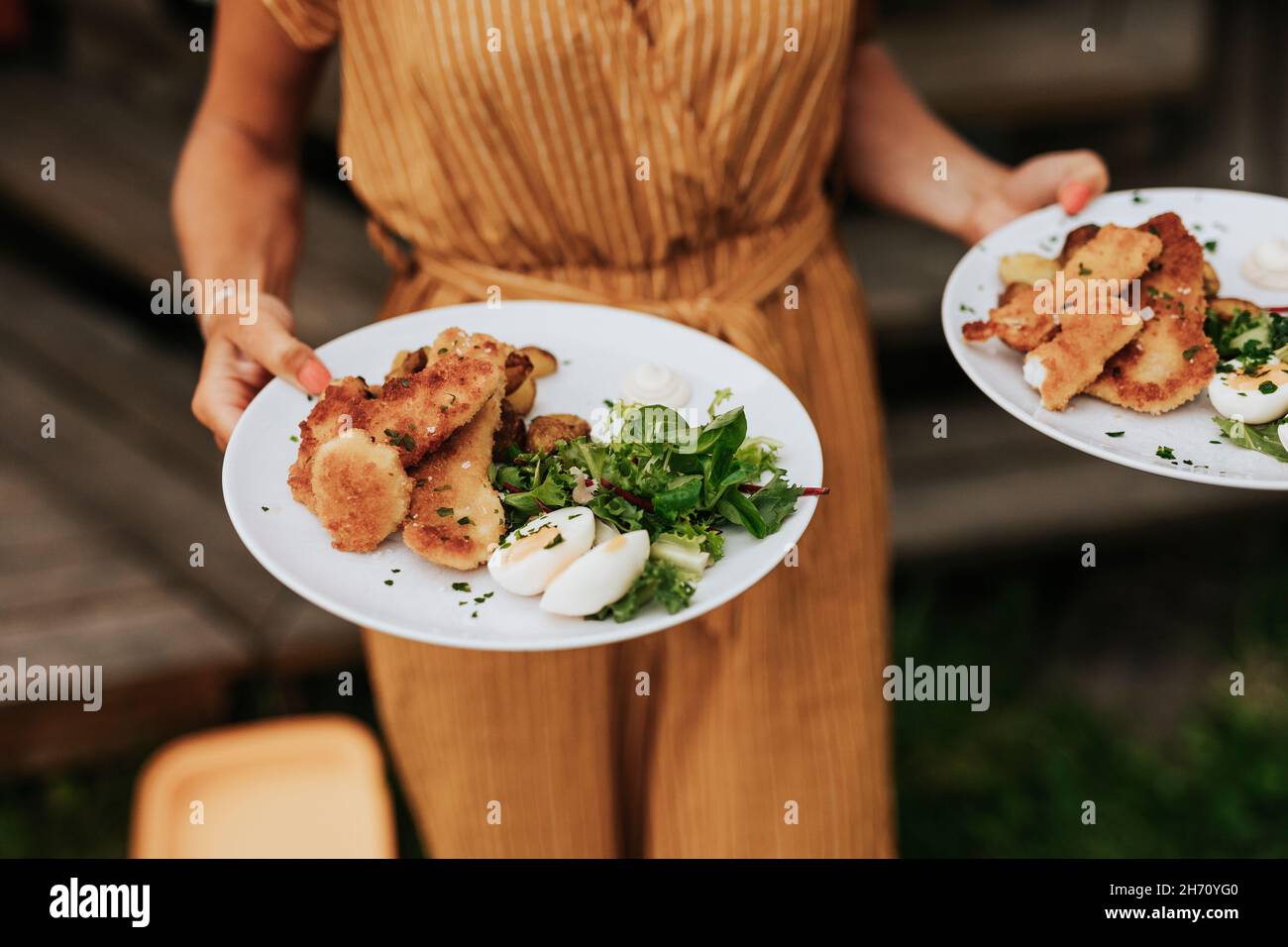 Woman holding plates with food Stock Photo - Alamy