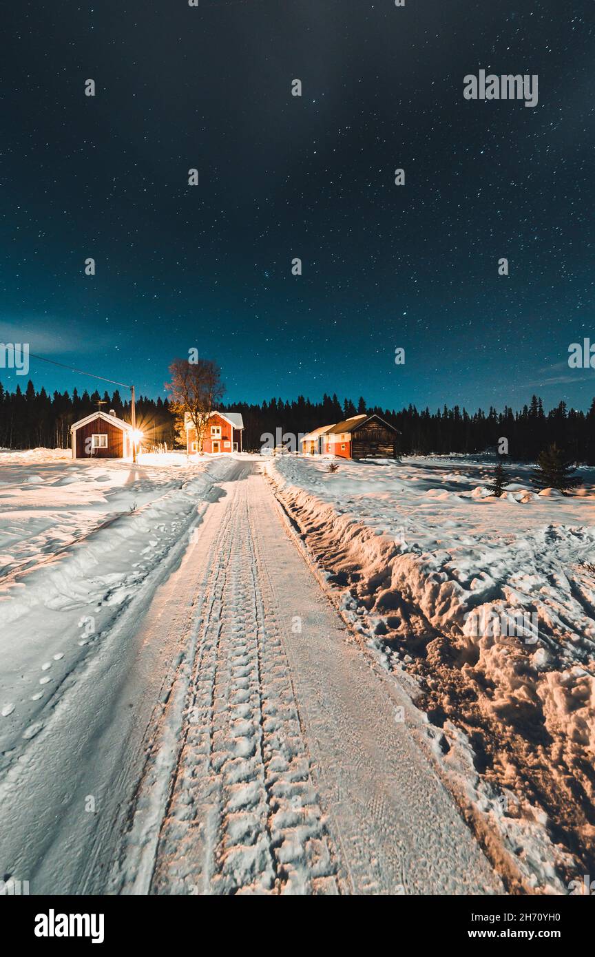 Snowy road and houses at night Stock Photo - Alamy