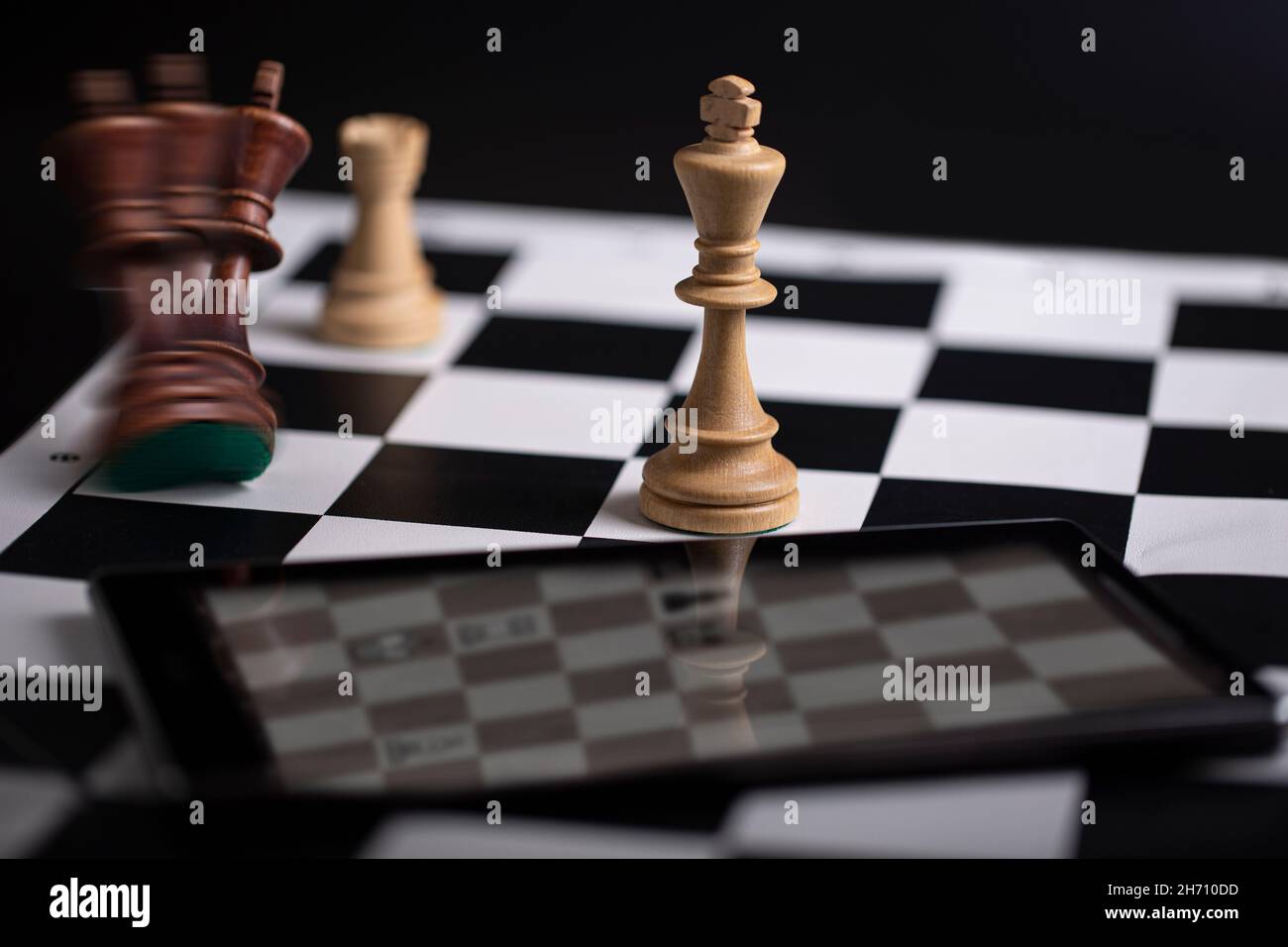 Chess pieces on a chessboard and smartphone. The concept of playing and ...