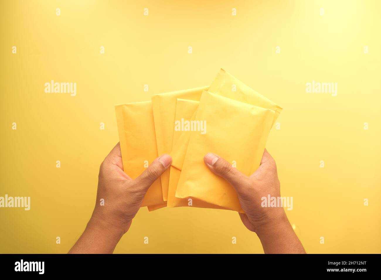 hand hold yellow paper bubble envelope top view Stock Photo - Alamy