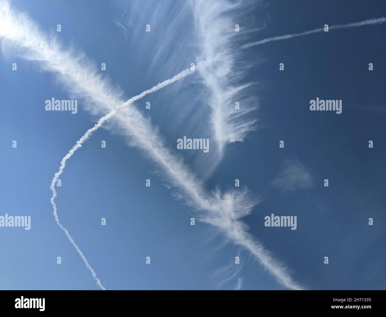 Clouds and airplane trails in the sky Stock Photo - Alamy