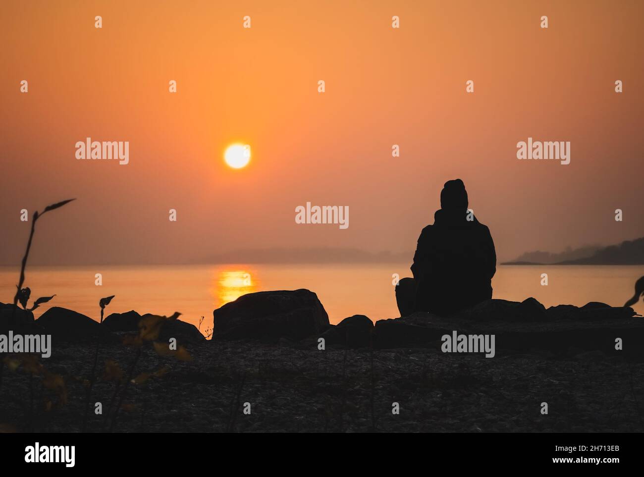 Scenic sunset by the sea. Big sun setting over the horizon. Silhouette ...
