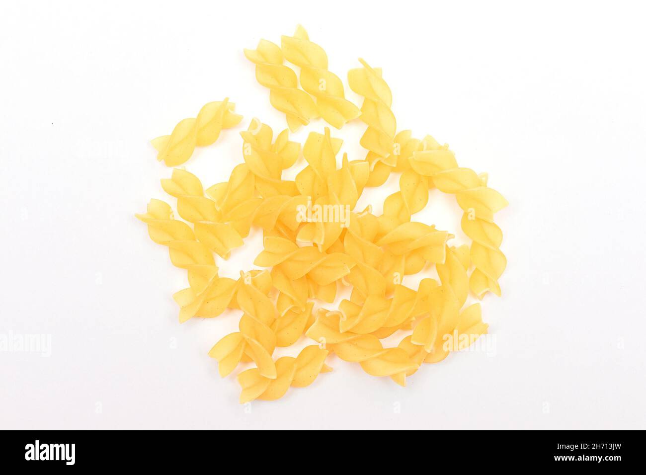 A Heap of Uncooked Fusilli Pasta Scattered on White Table. Raw and Dry ...
