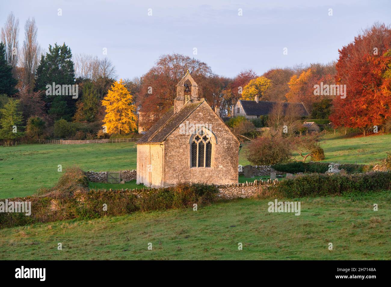 Sunrise over St Oswald's church in autumn. Widford, Cotswolds ...