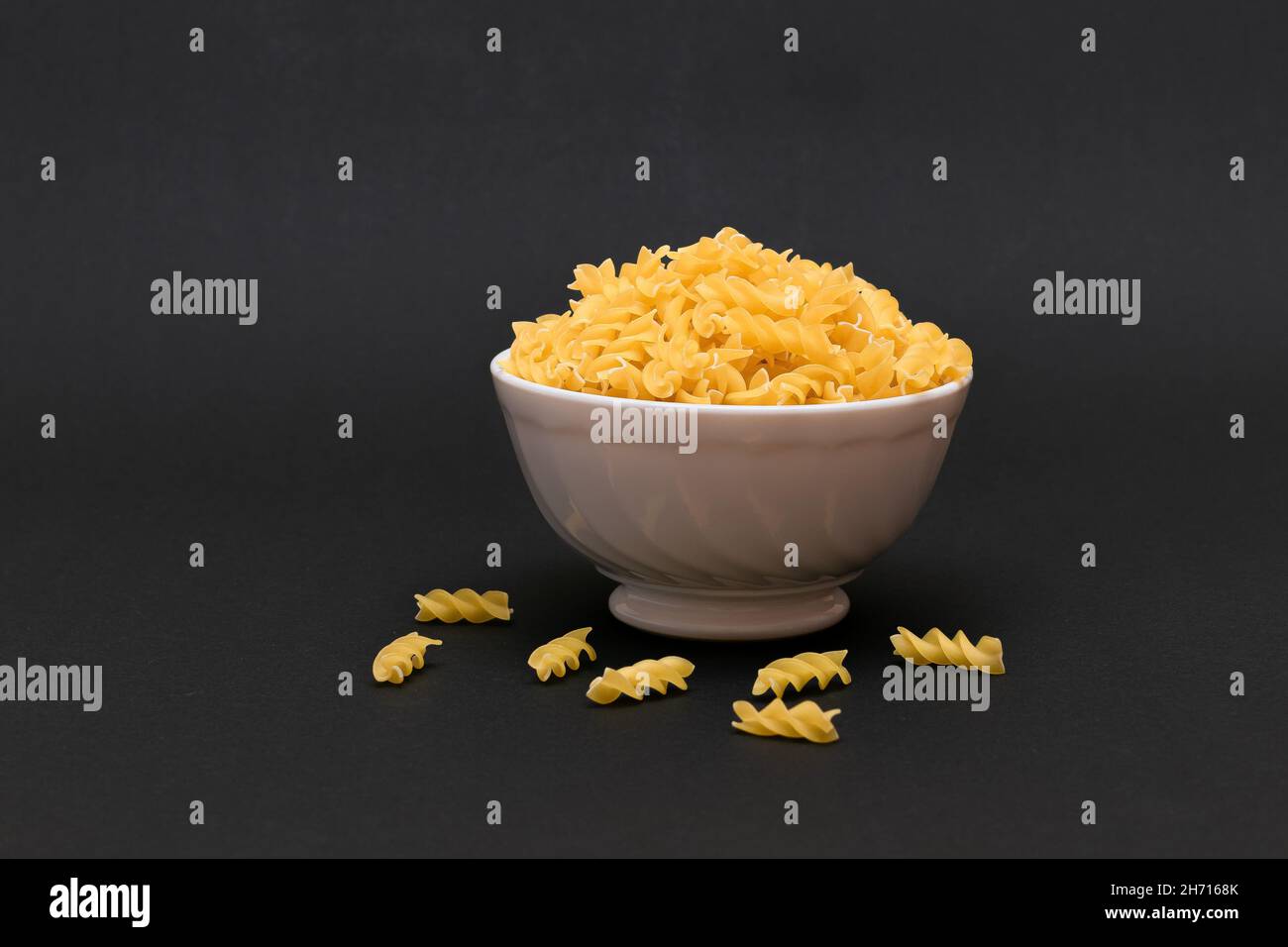 Uncooked Fusilli Pasta in White Bowl on Black Table. Raw and Dry ...
