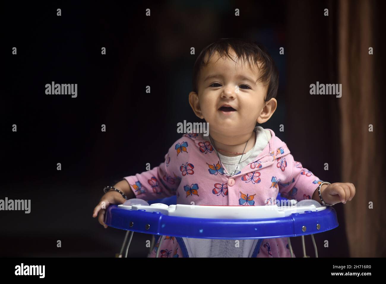 First steps of an Indian girl in a baby walker Stock Photo - Alamy