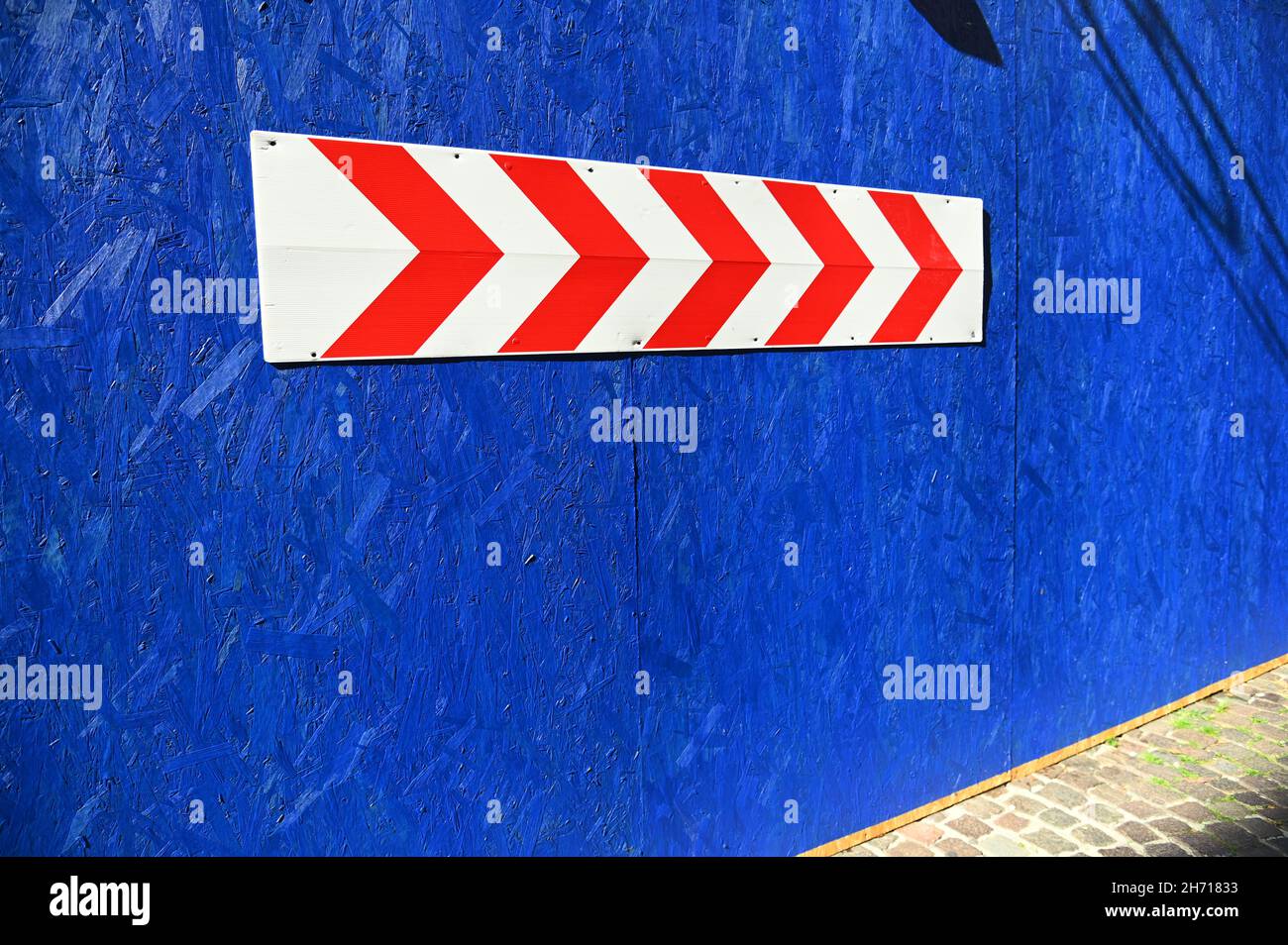 Close-up shot of a red and white right arrow direction sign attached to ...