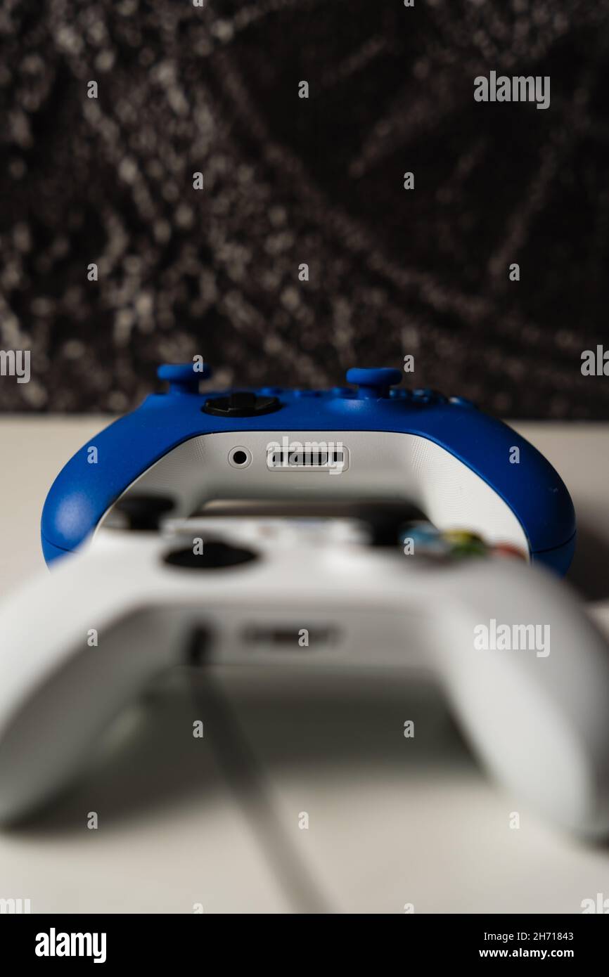 Vertical selective focus shot of a blue XBOX controller on a white ...