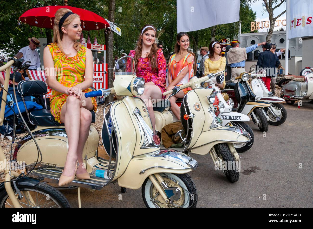 Females in sixties period dress posing on vintage motor scooters at the ...