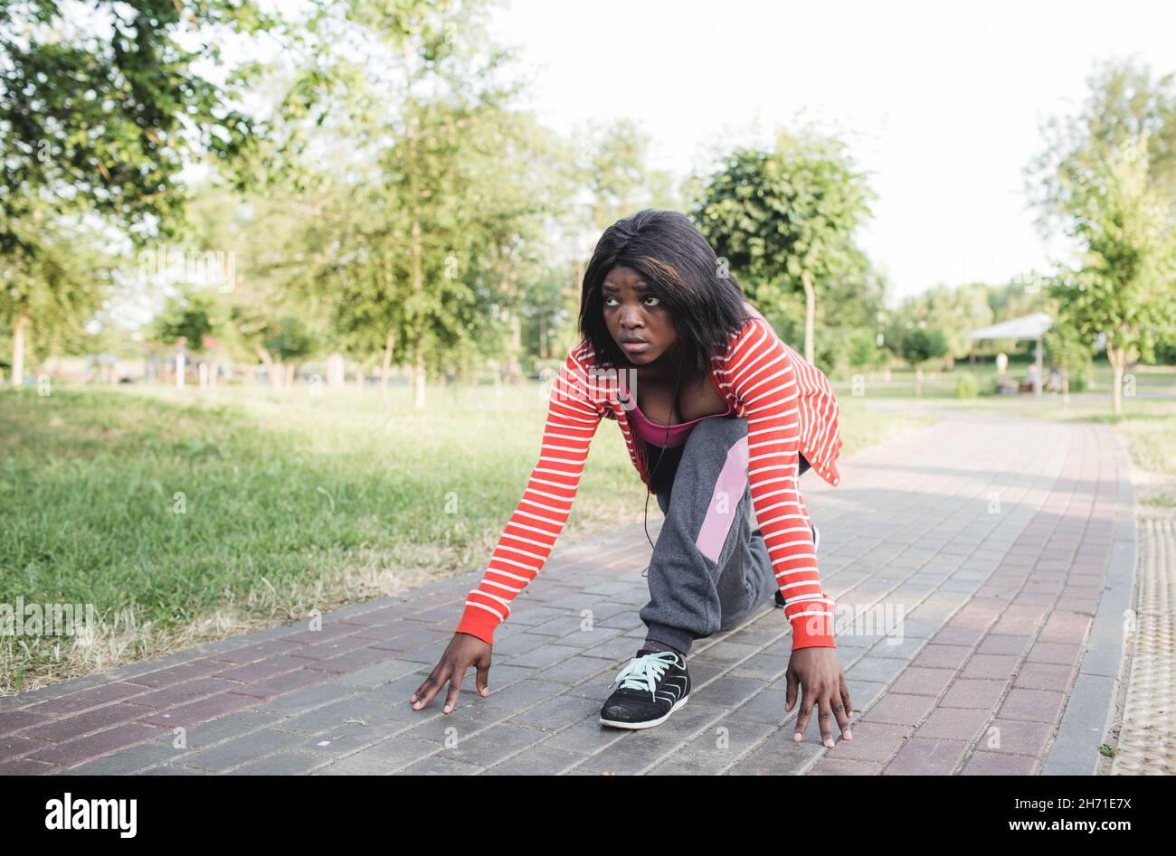 An African-American girl is getting ready for a run. low position to ...
