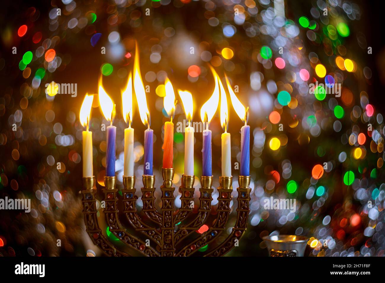Burning candles on menorah for Hanukkah on defocus color lights ...