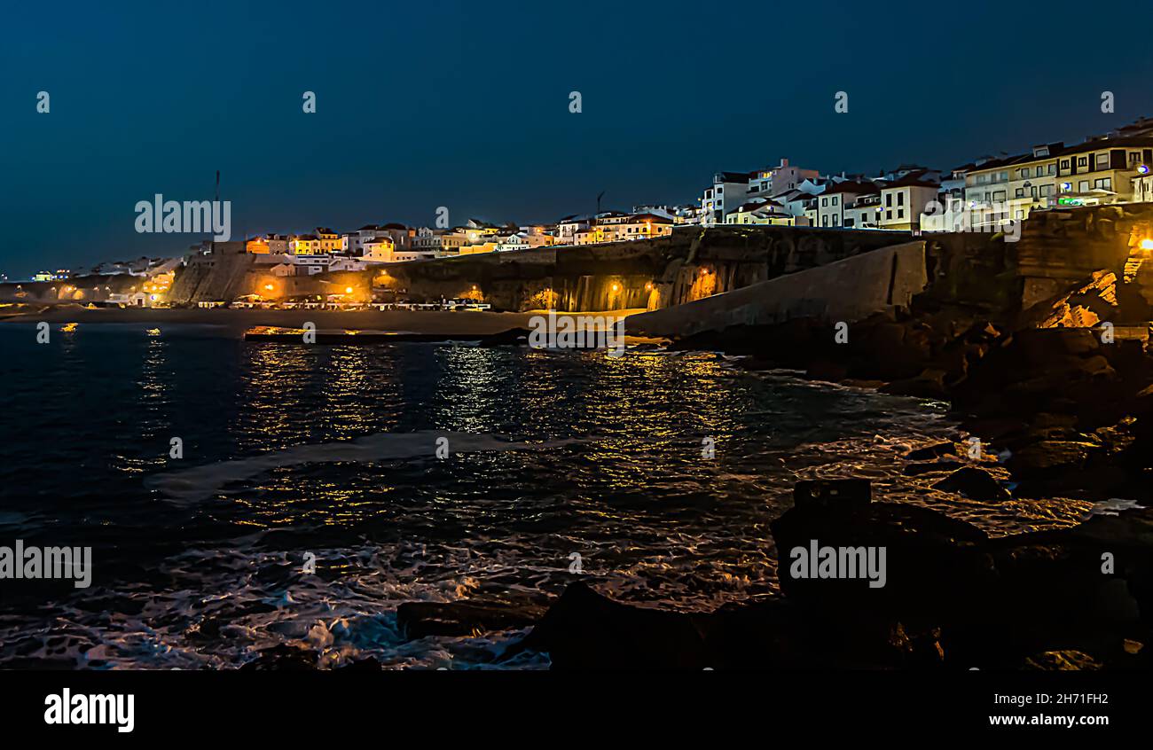 Scenic night view in a bay with buildings illuminated on the shore ...
