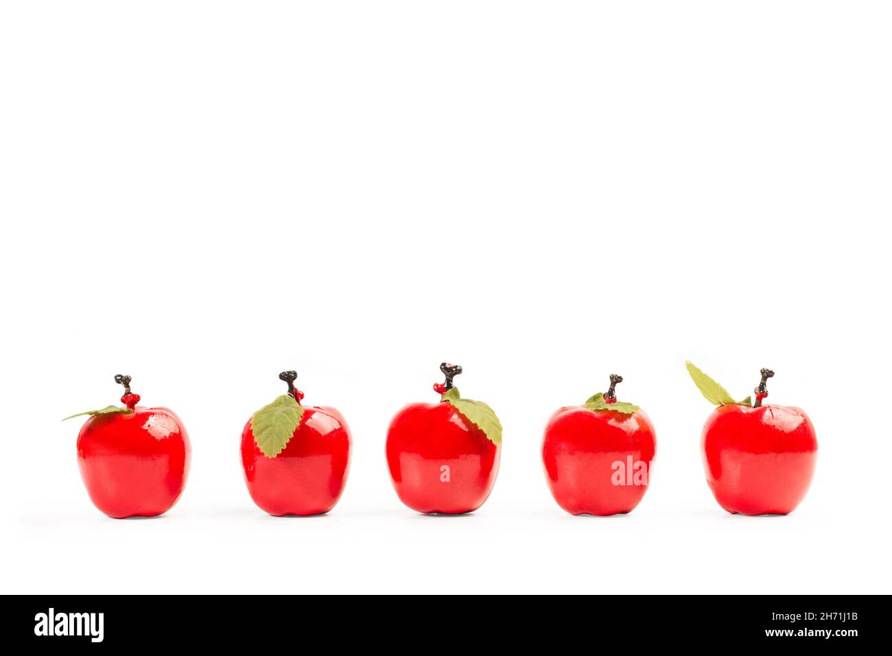 Five red plastic apples on a white background Stock Photo - Alamy