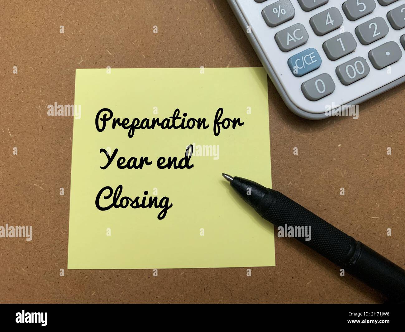 Preparation for year end text on sticky note with calculator and pen ...