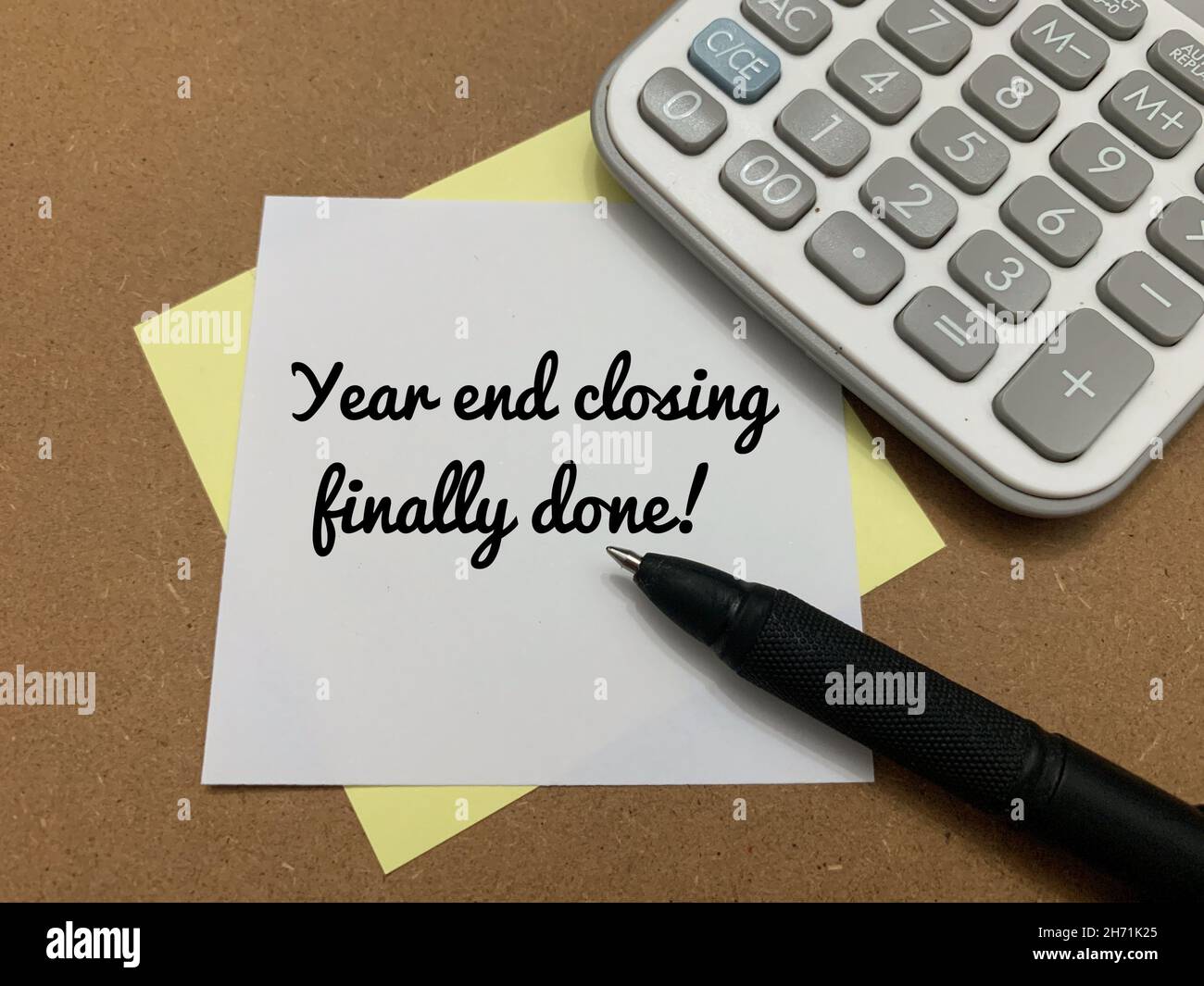 Year end closing finally done text on note pad with calculator and pen ...