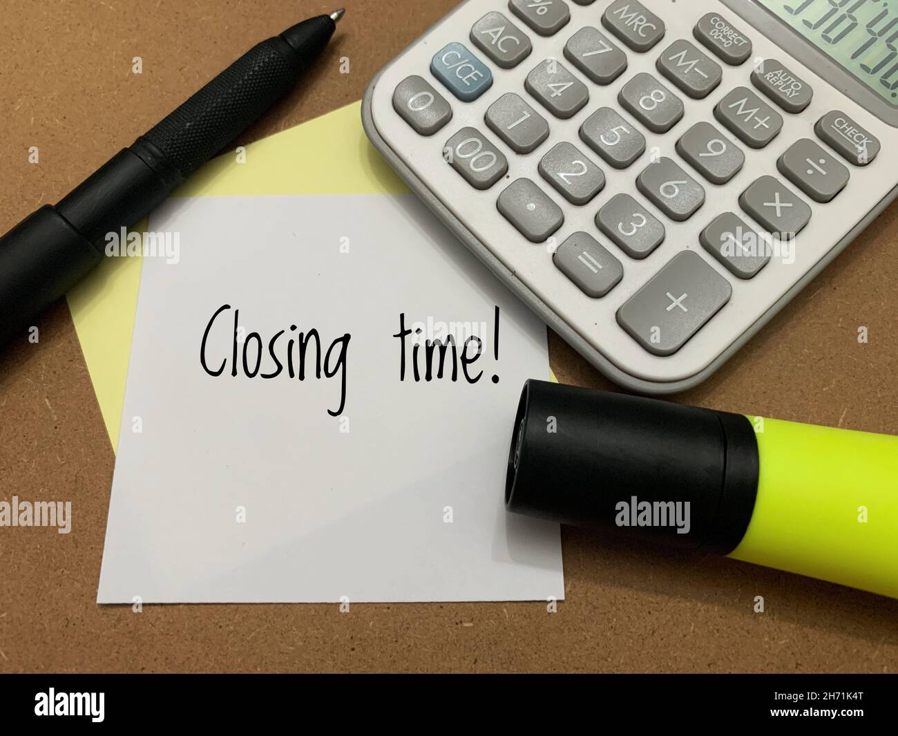 Closing time text on sticky note with calculator, highlighter and pen ...