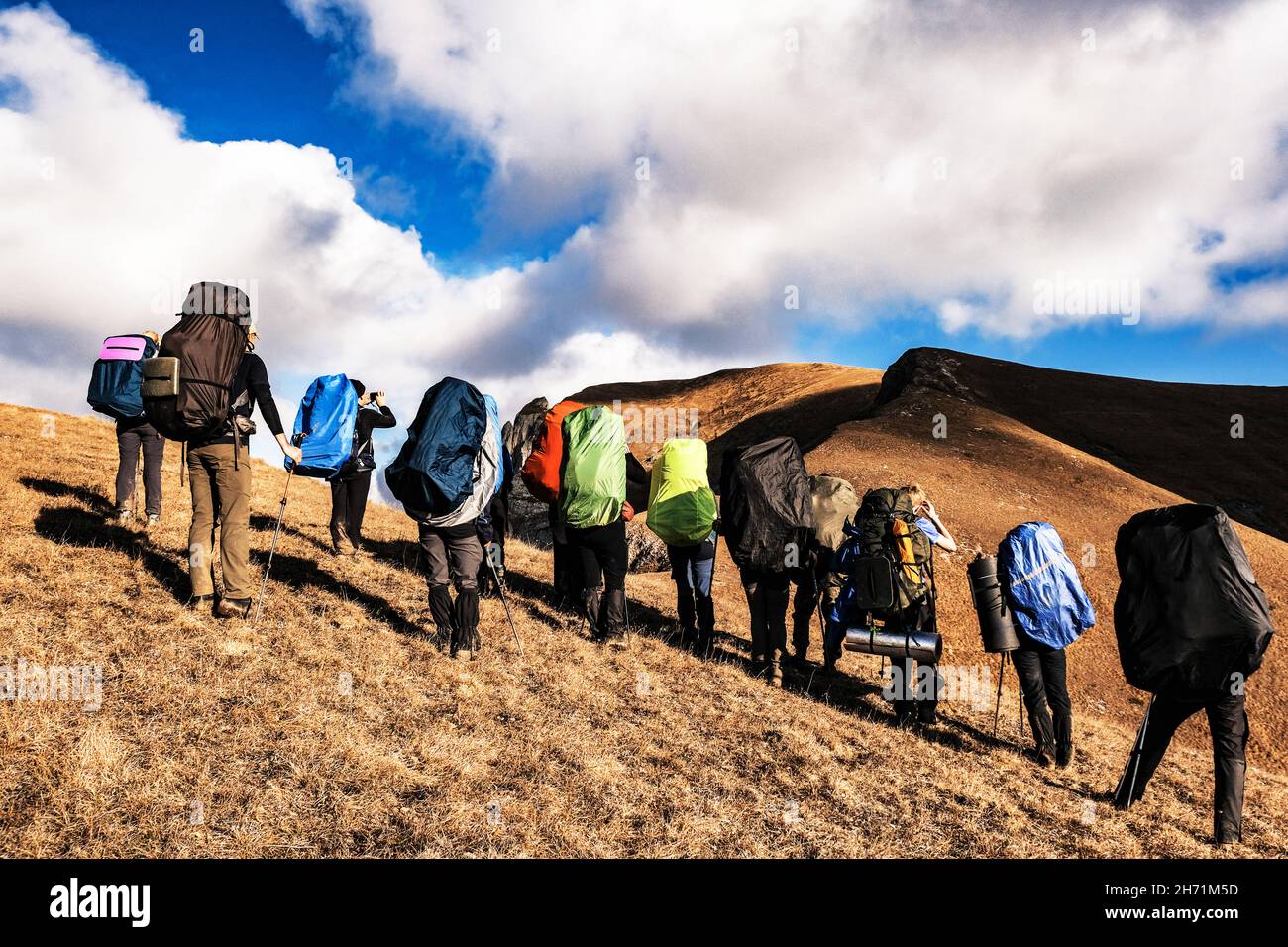 Group of travelers with big backpacks on the mountains. Back view Stock ...