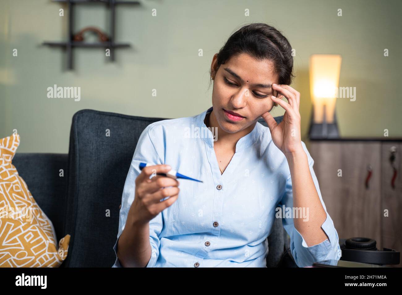 Worried sick girl got sad over checking temperature using thermometer ...