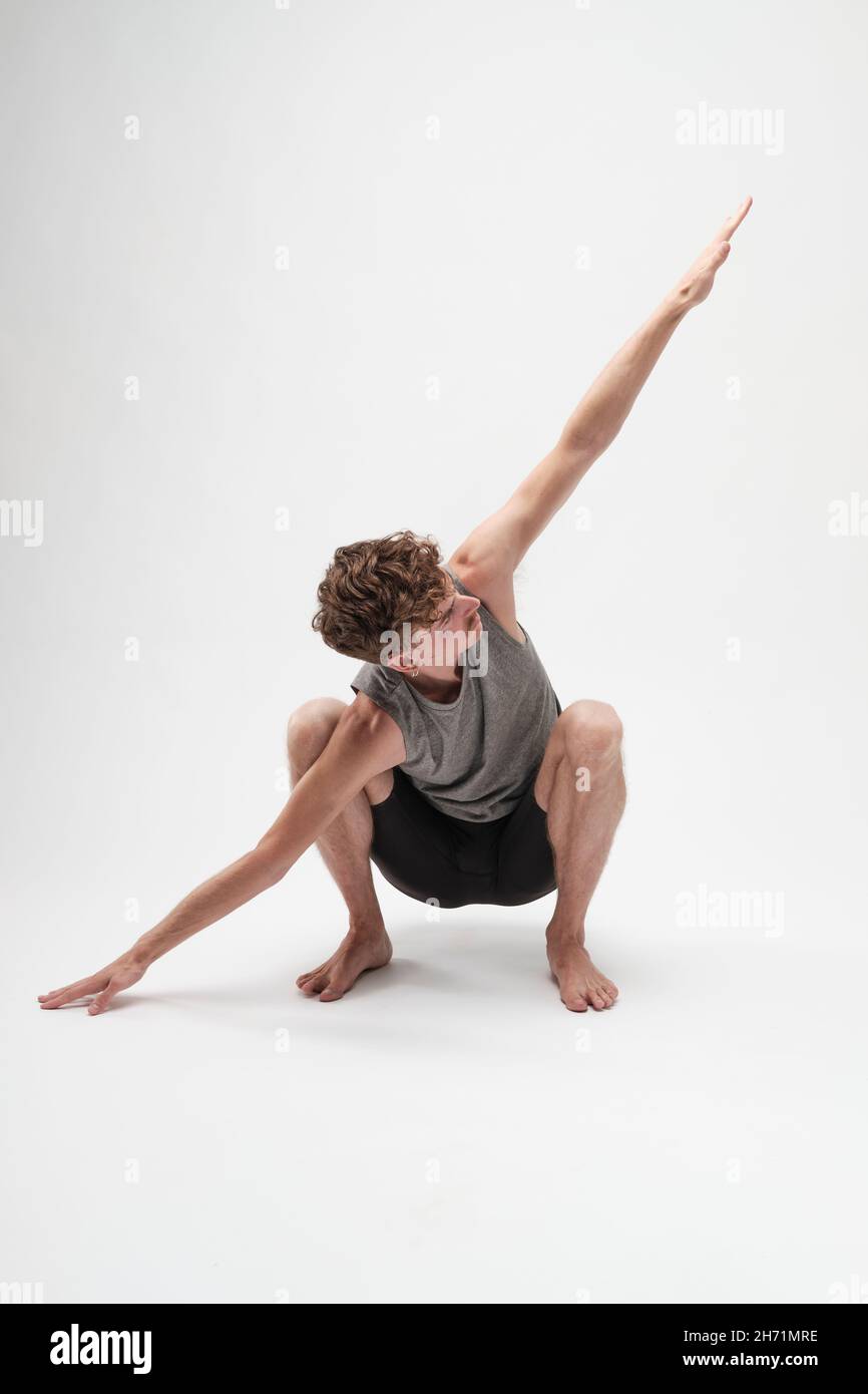 Young boy streching his arms while resting in a low position on white ...
