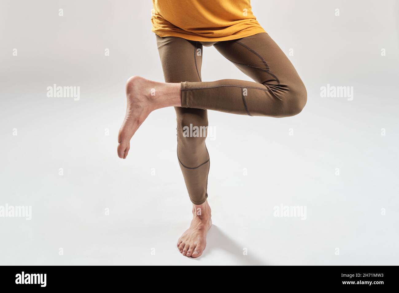 Crossed legs of a young man balancing over one leg Stock Photo - Alamy