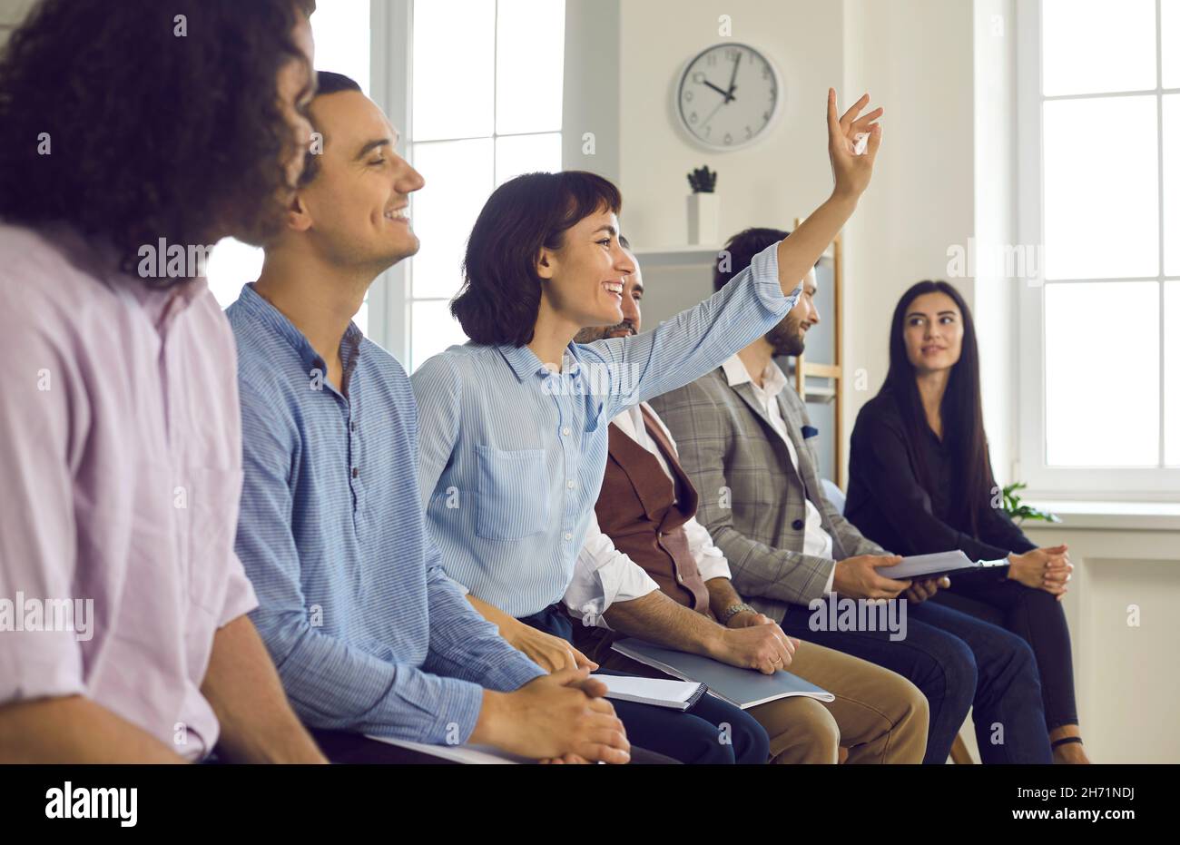 Group of young happy office workers are sitting on a business training ...