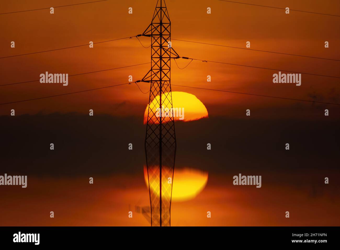 Beautiful view of the sunset behind an electricity tower Stock Photo ...