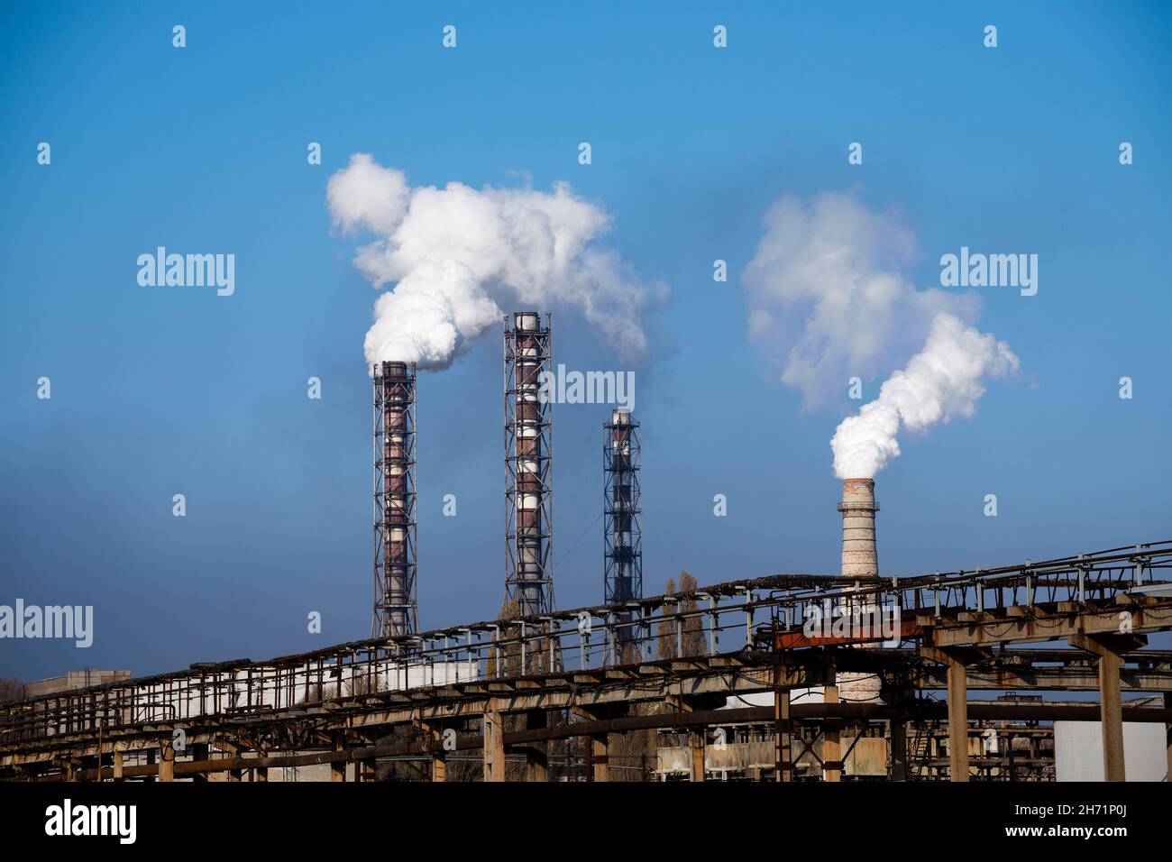 Smoke stack over chemical plant on blue sky background Stock Photo - Alamy