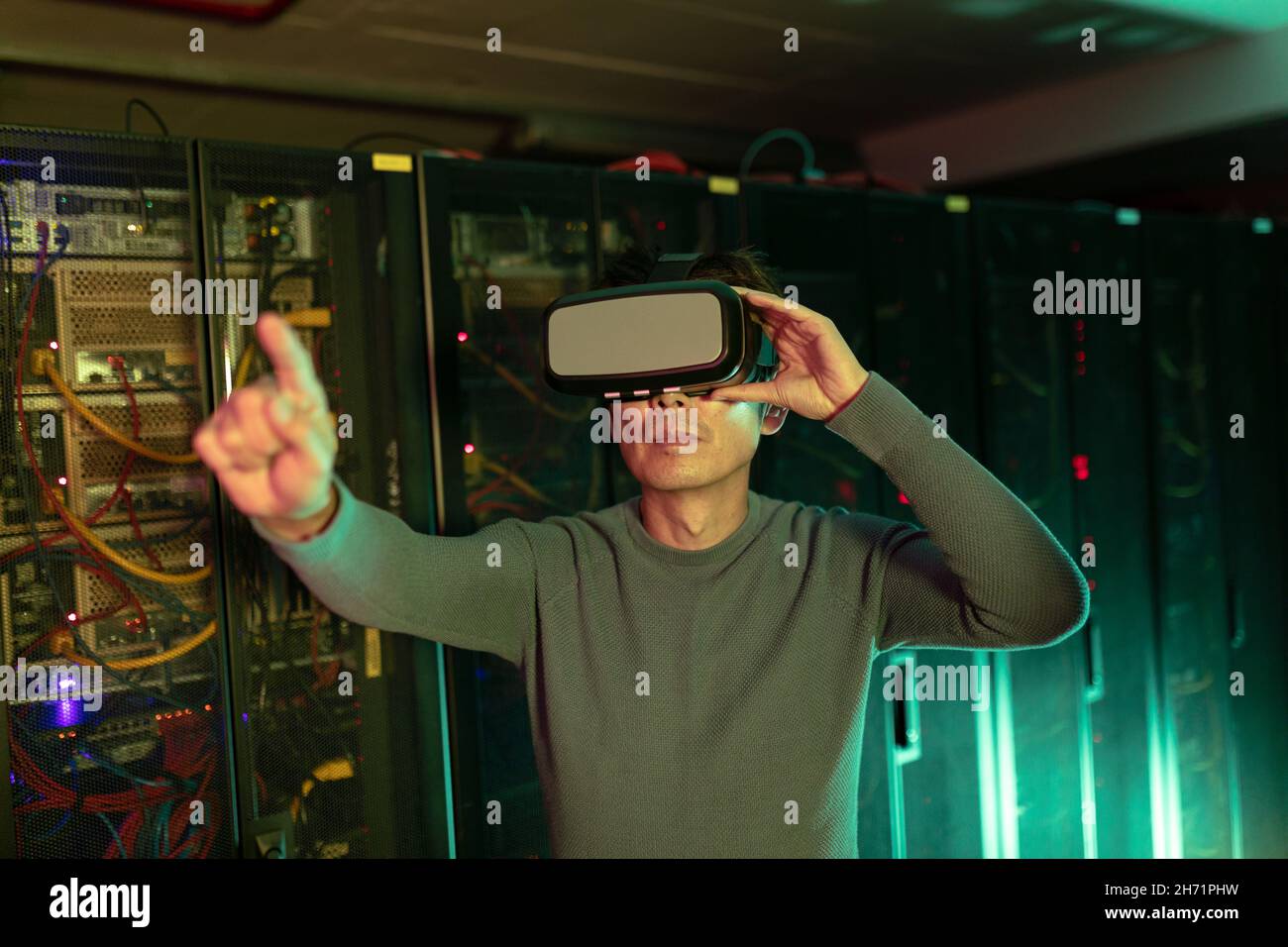 Asian man wearing vr headset touching an invisible screen in computer ...