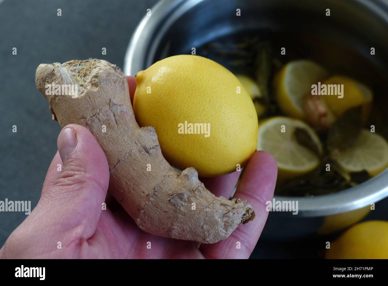 Hand holding ginger and lemon for flu Stock Photo - Alamy