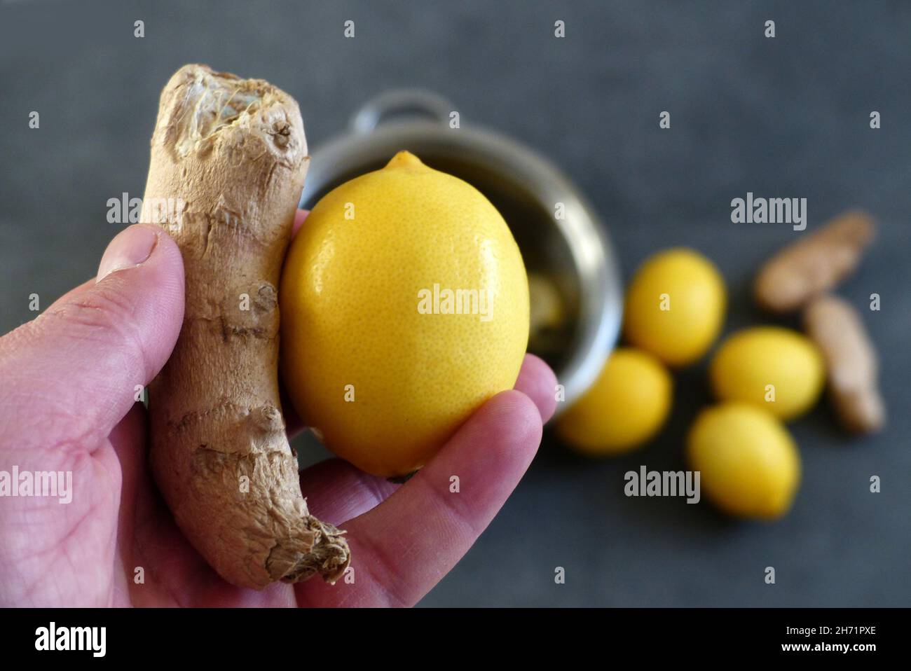 Hand holding ginger and lemon for flu Stock Photo - Alamy