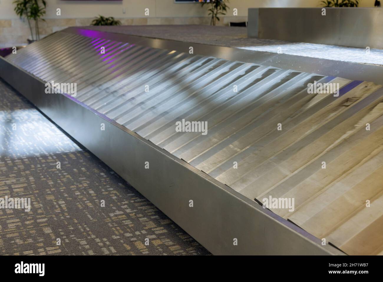 Baggage claim area with conveyor belt in arrivals lounge of airport ...