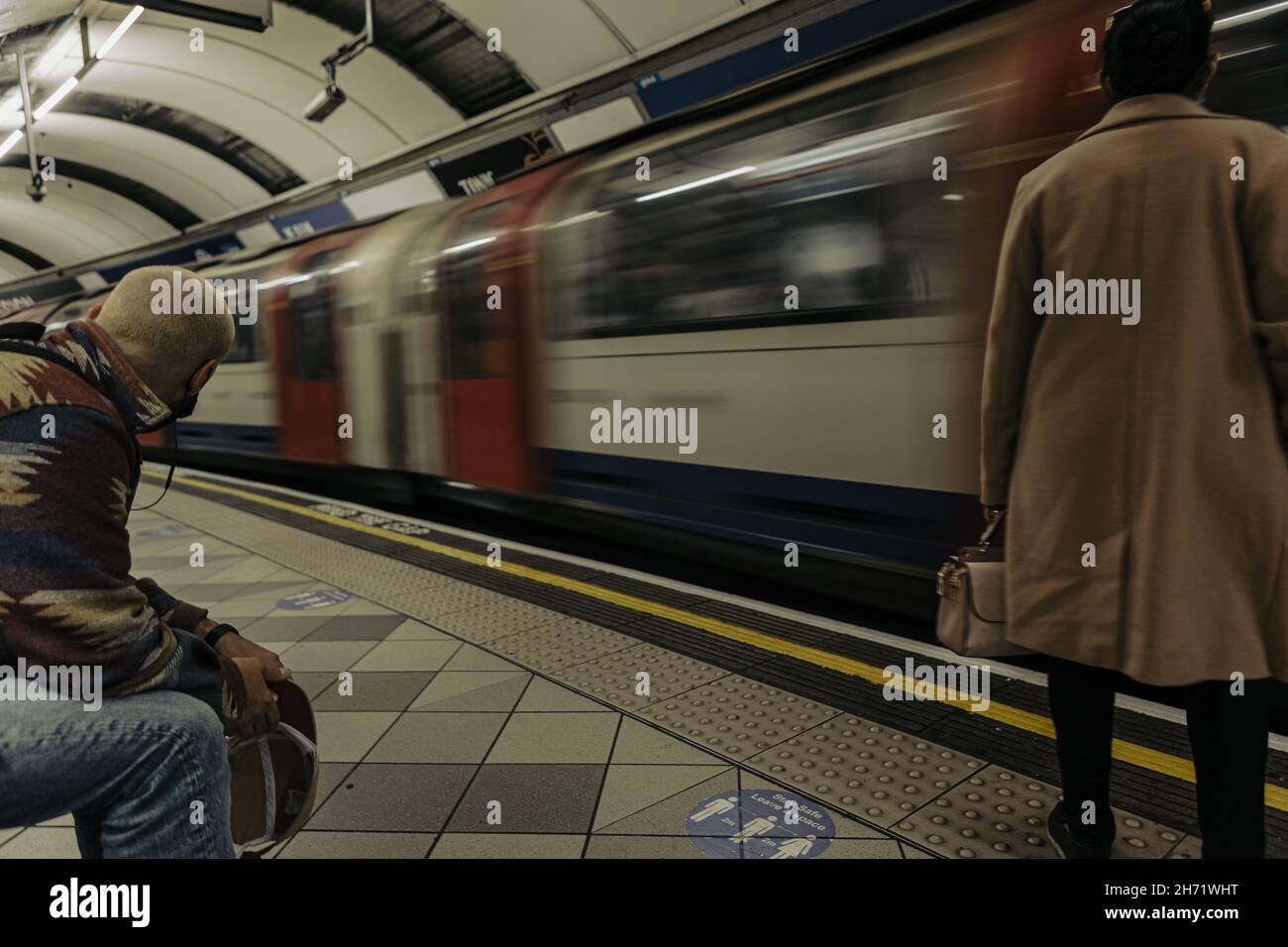 People waiting for the arriving train in the subway of London, Great ...