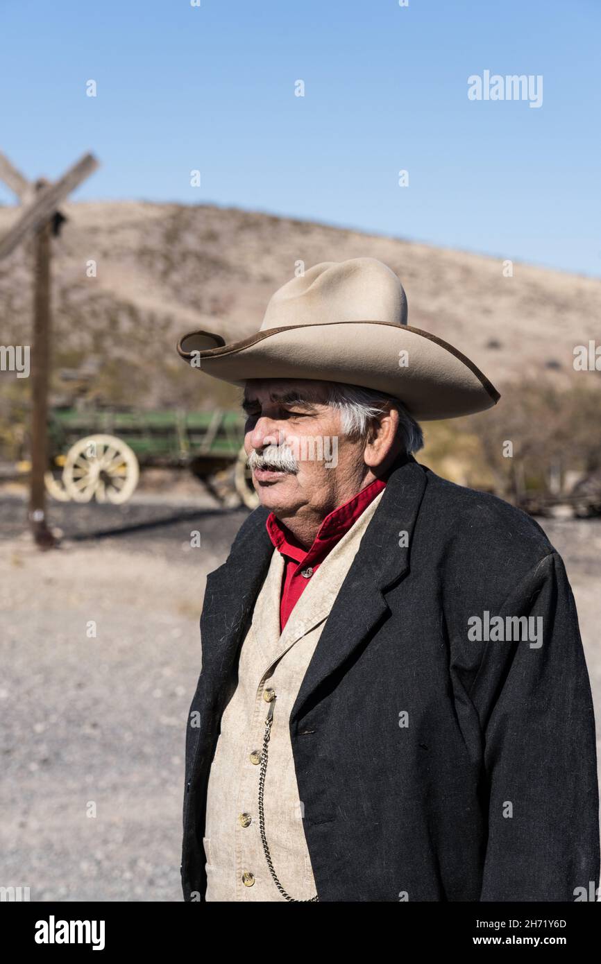 An old cowboy in period dress guides a tour through the old ghost town ...