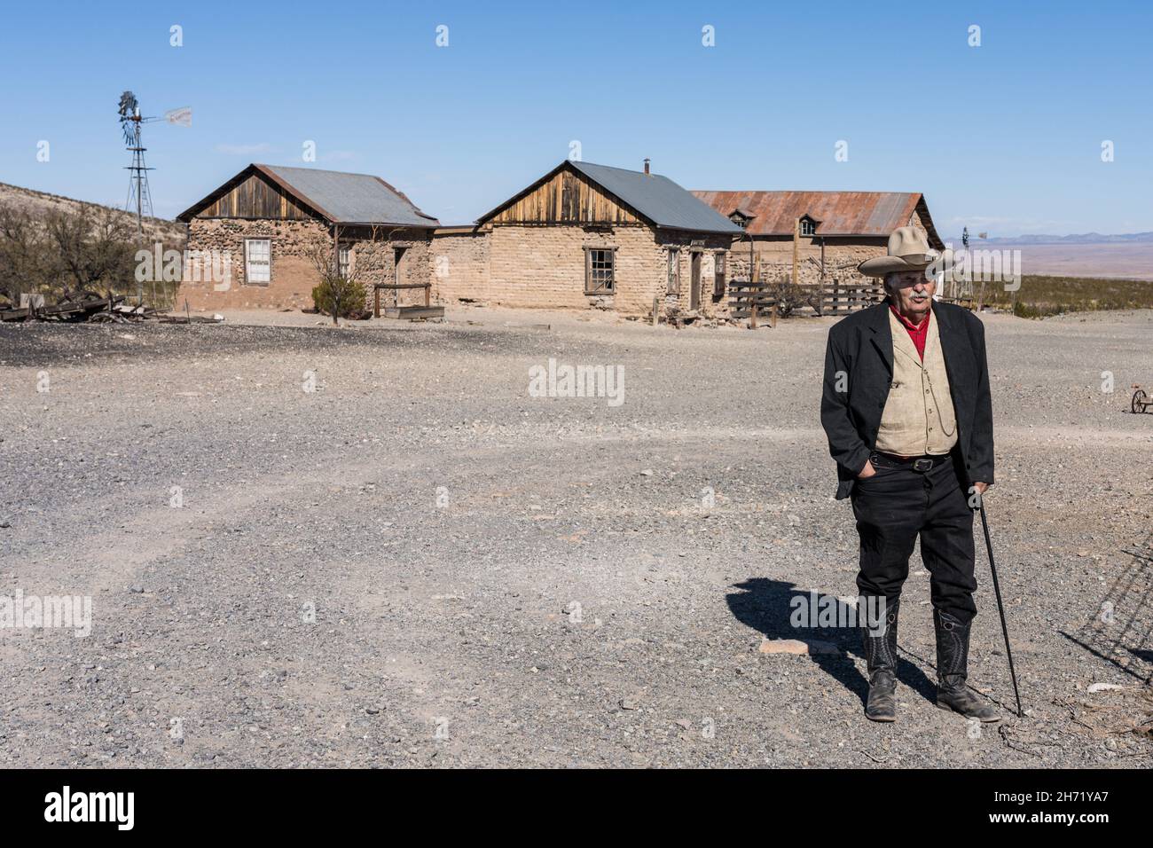 An old cowboy in period dress guides a tour through the old ghost town ...