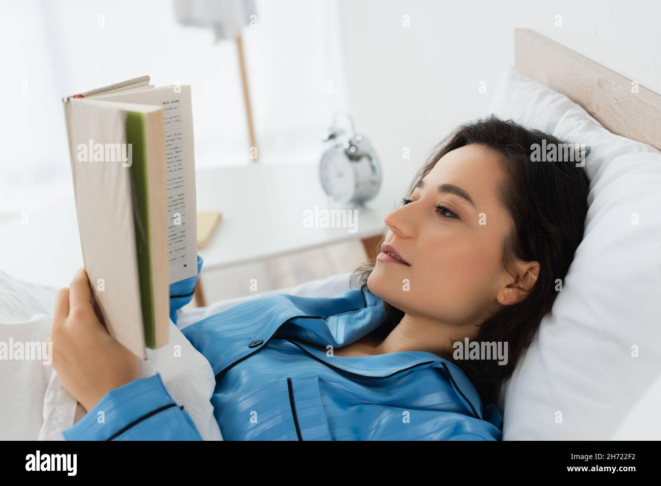 Brunette lying in bed reading hi-res stock photography and images - Alamy