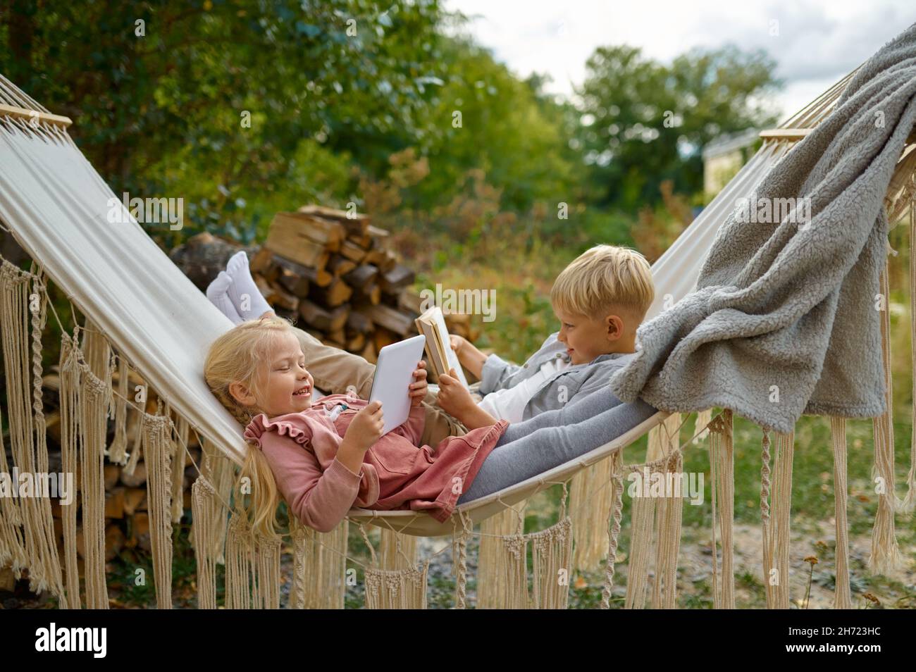 Funny kids lying in a hammock, summer camping Stock Photo - Alamy