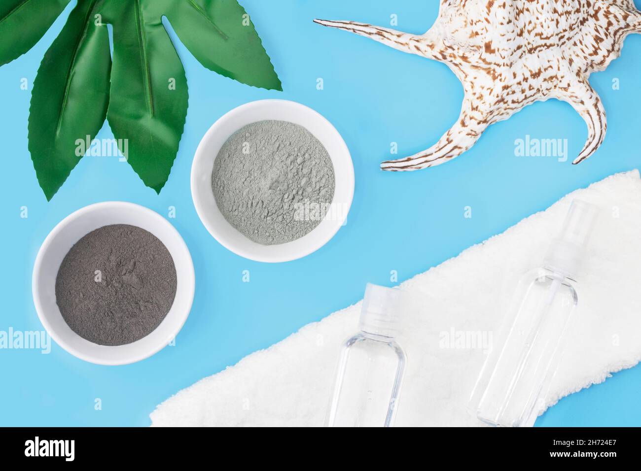 Cosmetic clay on a blue background, next to a towel, sea shell, and ...